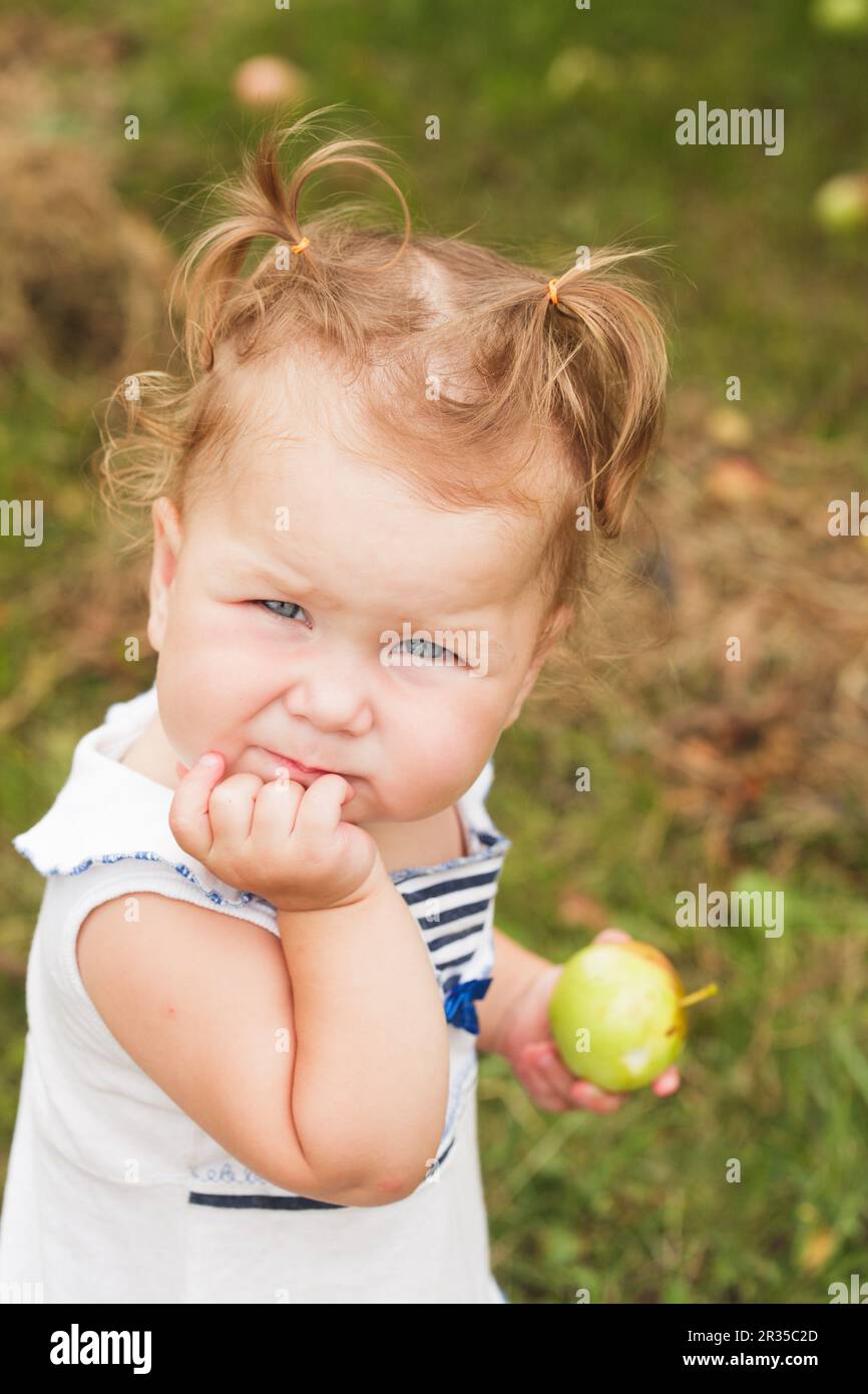 Baby girl under the apple tree Stock Photo - Alamy