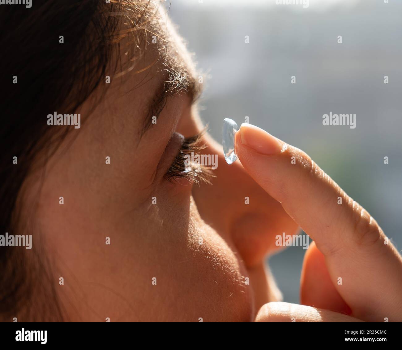 Woman putting contact lenses hi-res stock photography and images - Alamy
