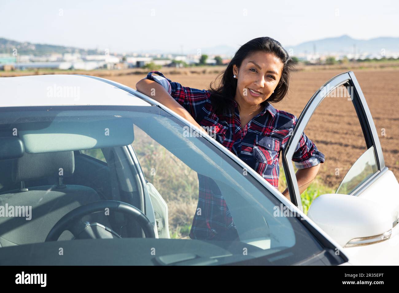 Portrait of latino woman standing near car Stock Photo - Alamy