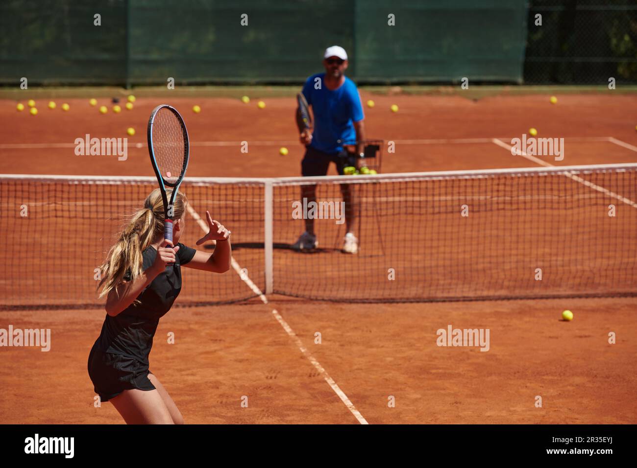 A professional tennis player and her coach training on a sunny day at ...