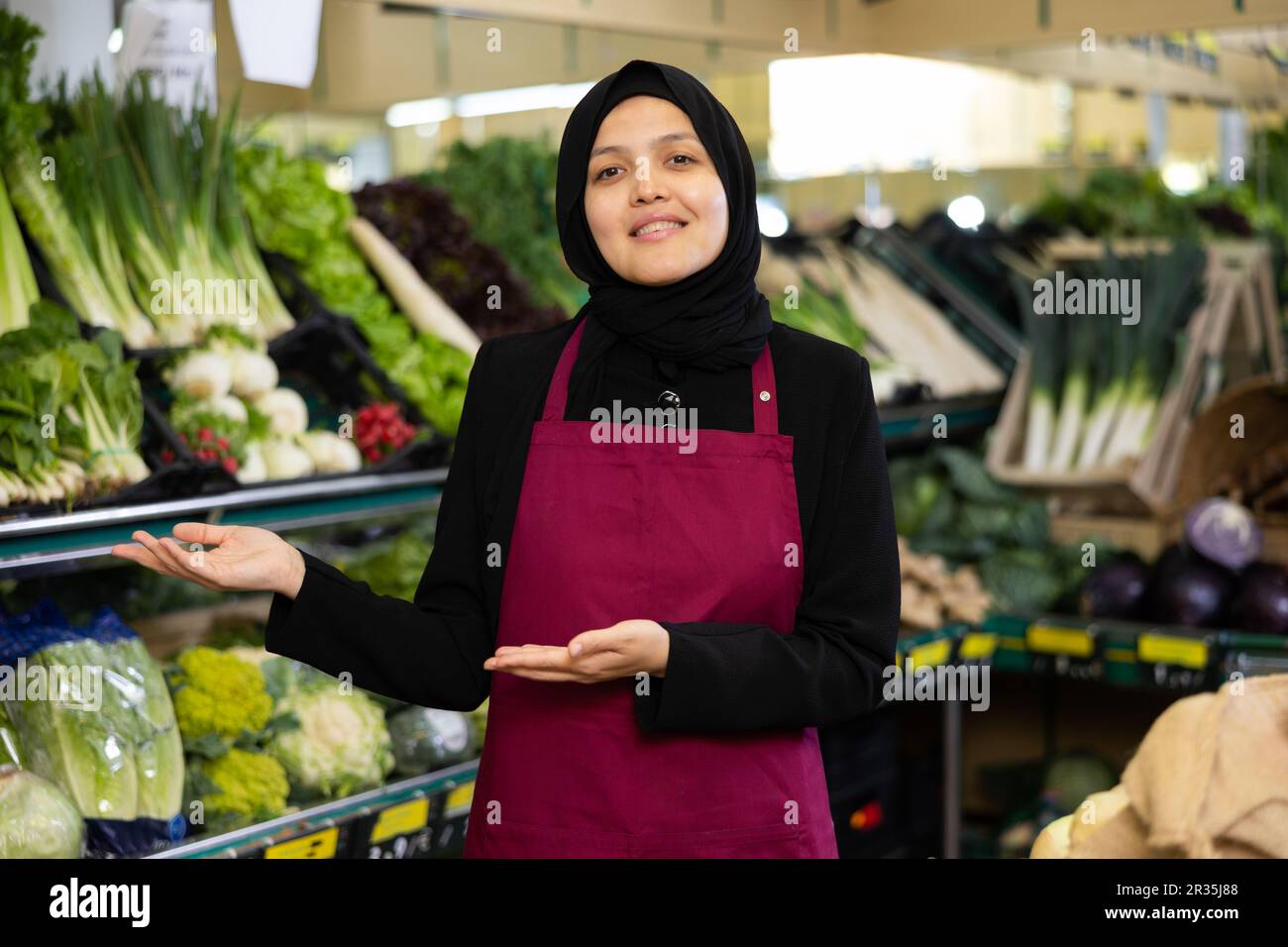 Muslim woman seller in hijab stands with arms crossed on chest and ...