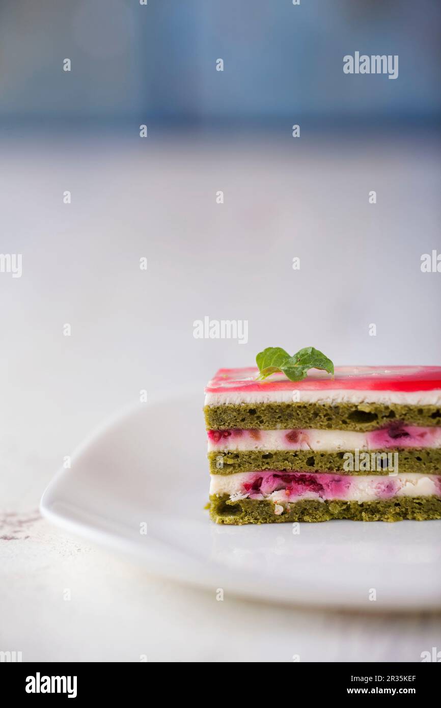 A slice of matcha cake with raspberry cream filling Stock Photo - Alamy