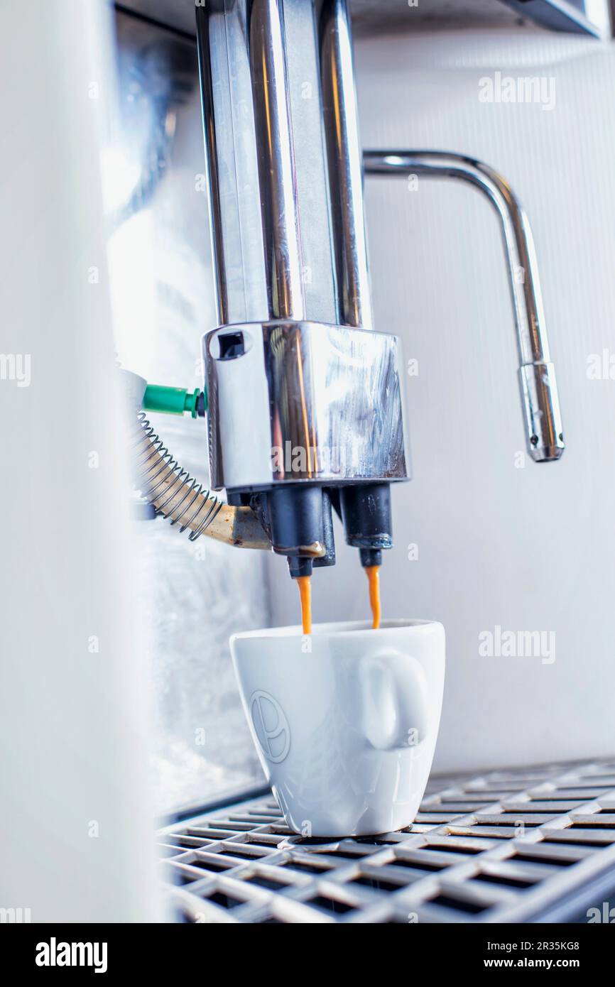 Coffee flowing from a coffee machine into a cup Stock Photo - Alamy