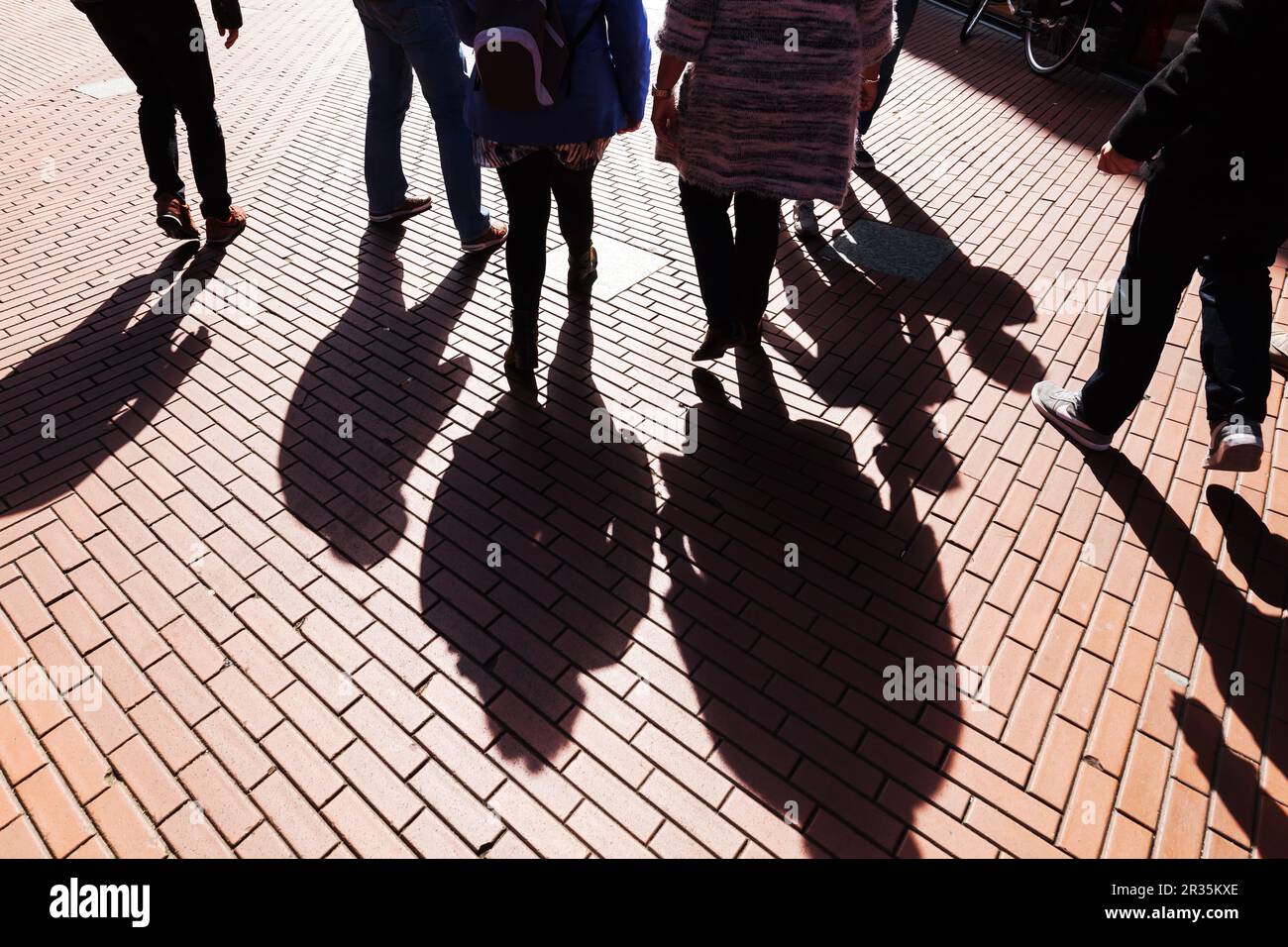 Crowd walking in shadow hi-res stock photography and images - Alamy