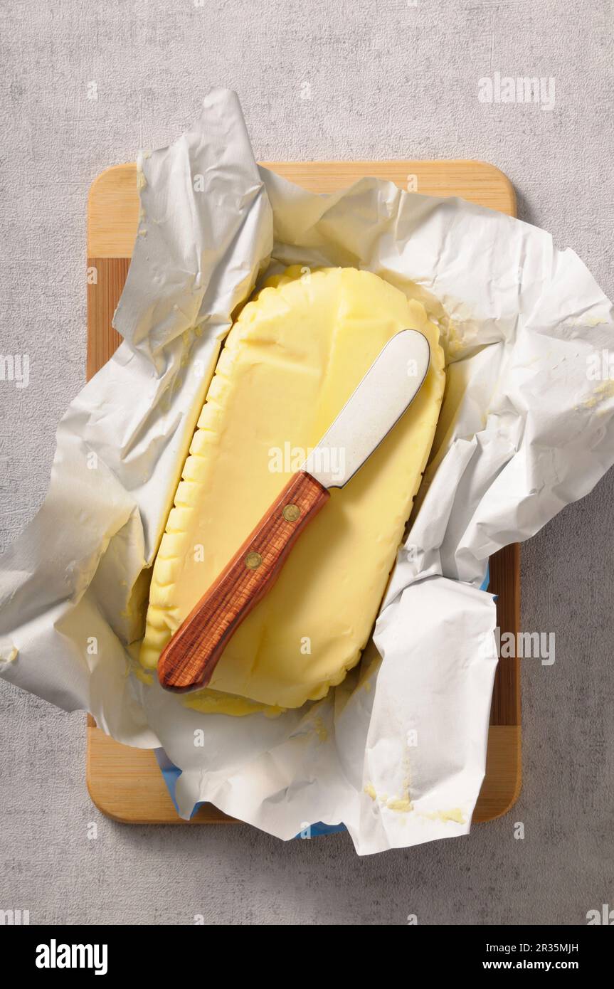 Butter on a piece of paper with a butter knife Stock Photo - Alamy