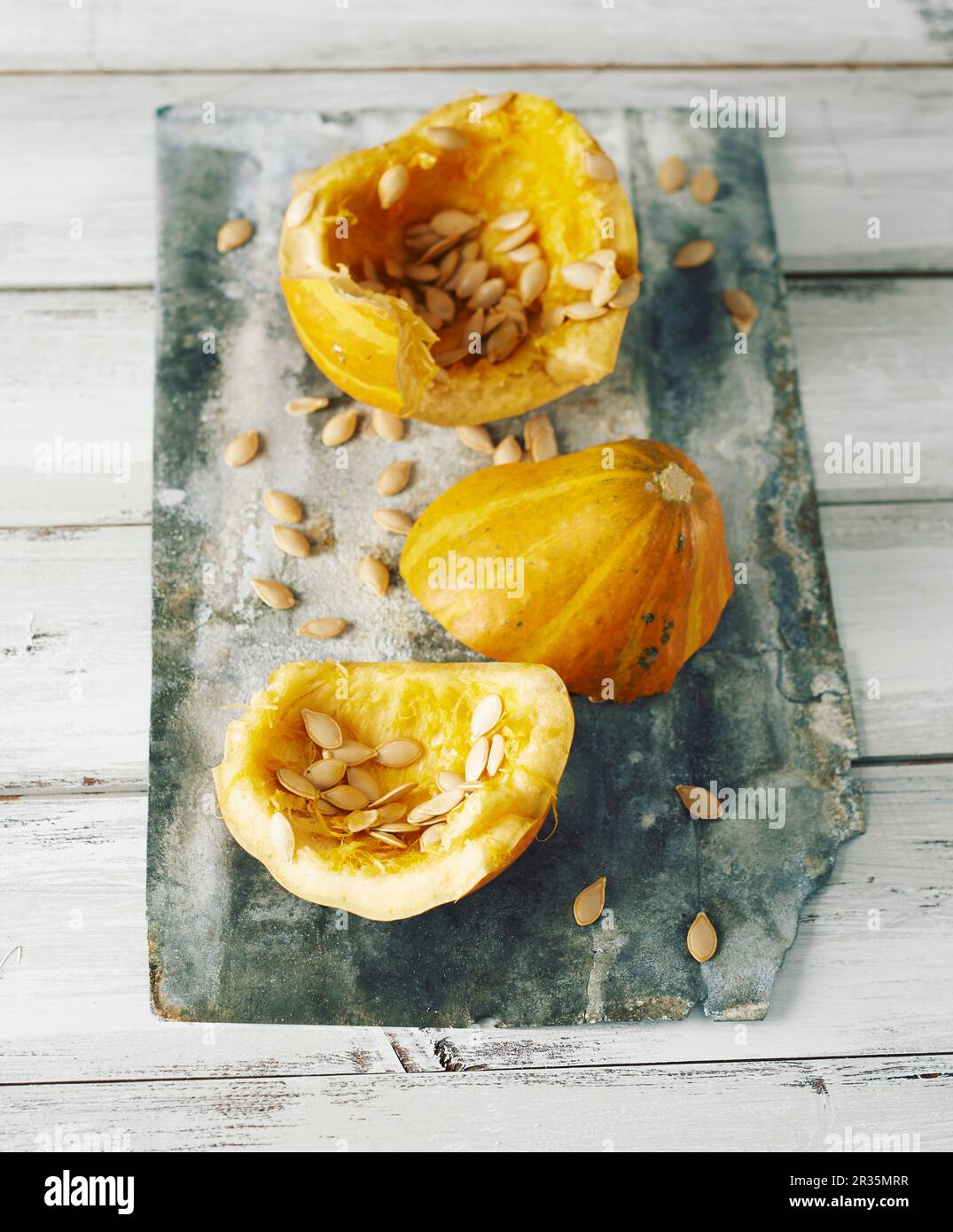 A sliced squash with seeds on a wooden board Stock Photo - Alamy