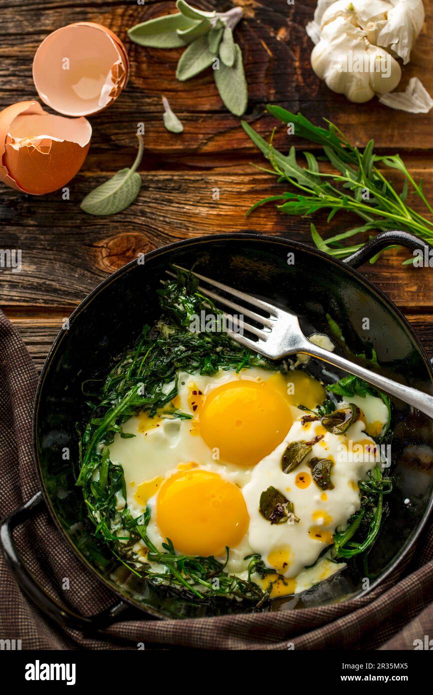 Fried eggs with rocket, yoghurt and chilli Stock Photo - Alamy