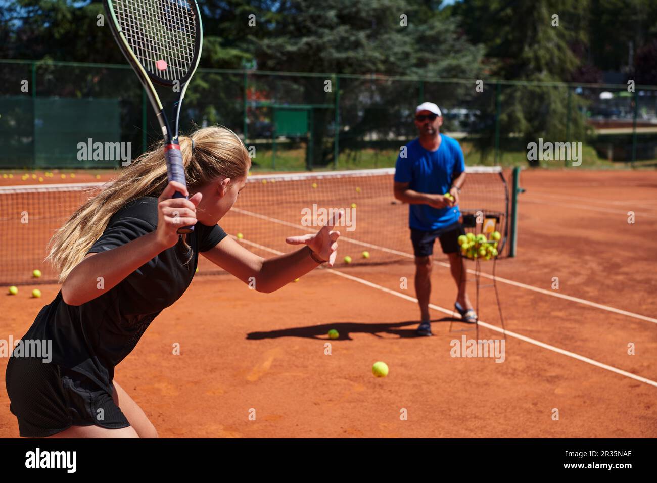 A professional tennis player and her coach training on a sunny day at ...