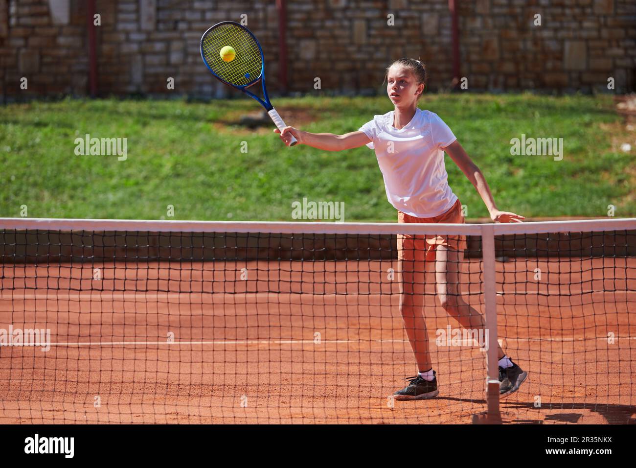 A young girl showing professional tennis skills in a competitive match ...