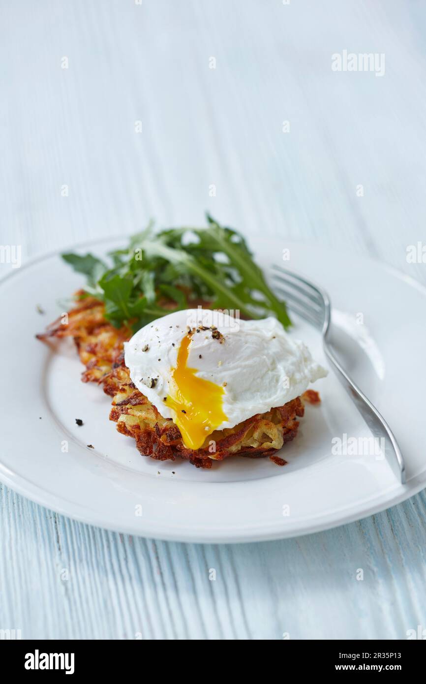 A potato fritter with a poached egg and rocket Stock Photo - Alamy
