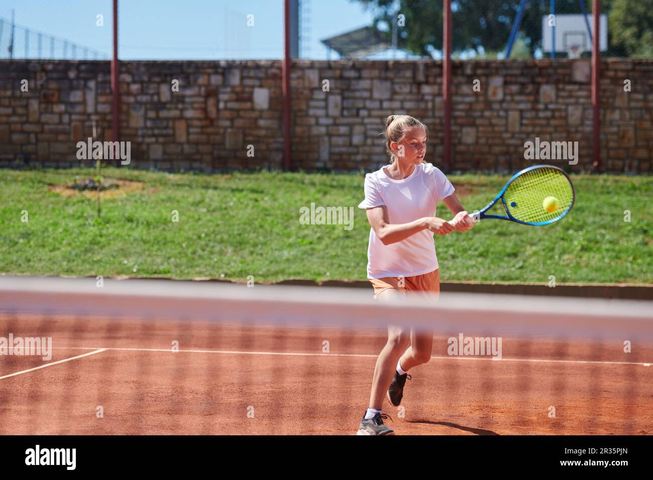 A young girl showing professional tennis skills in a competitive match ...