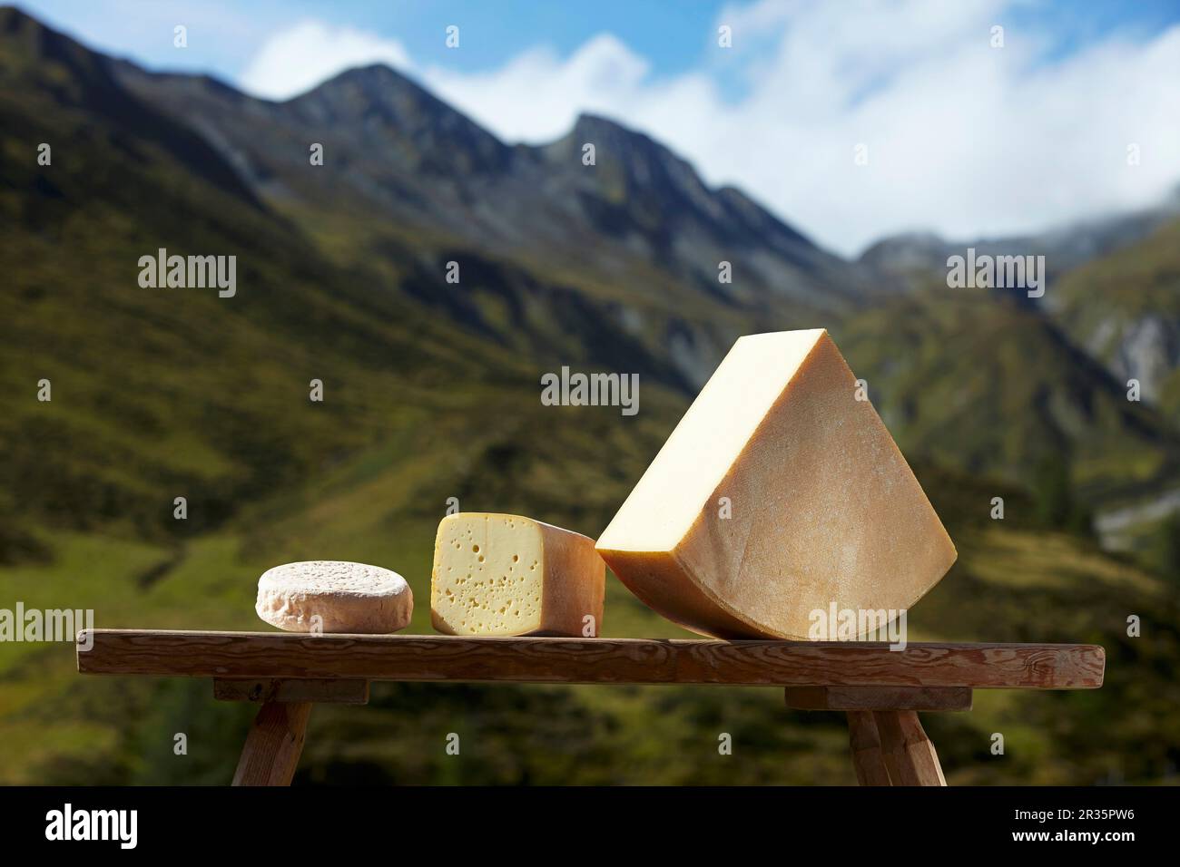 Alpine cheese against a mountain backdrop Stock Photo - Alamy
