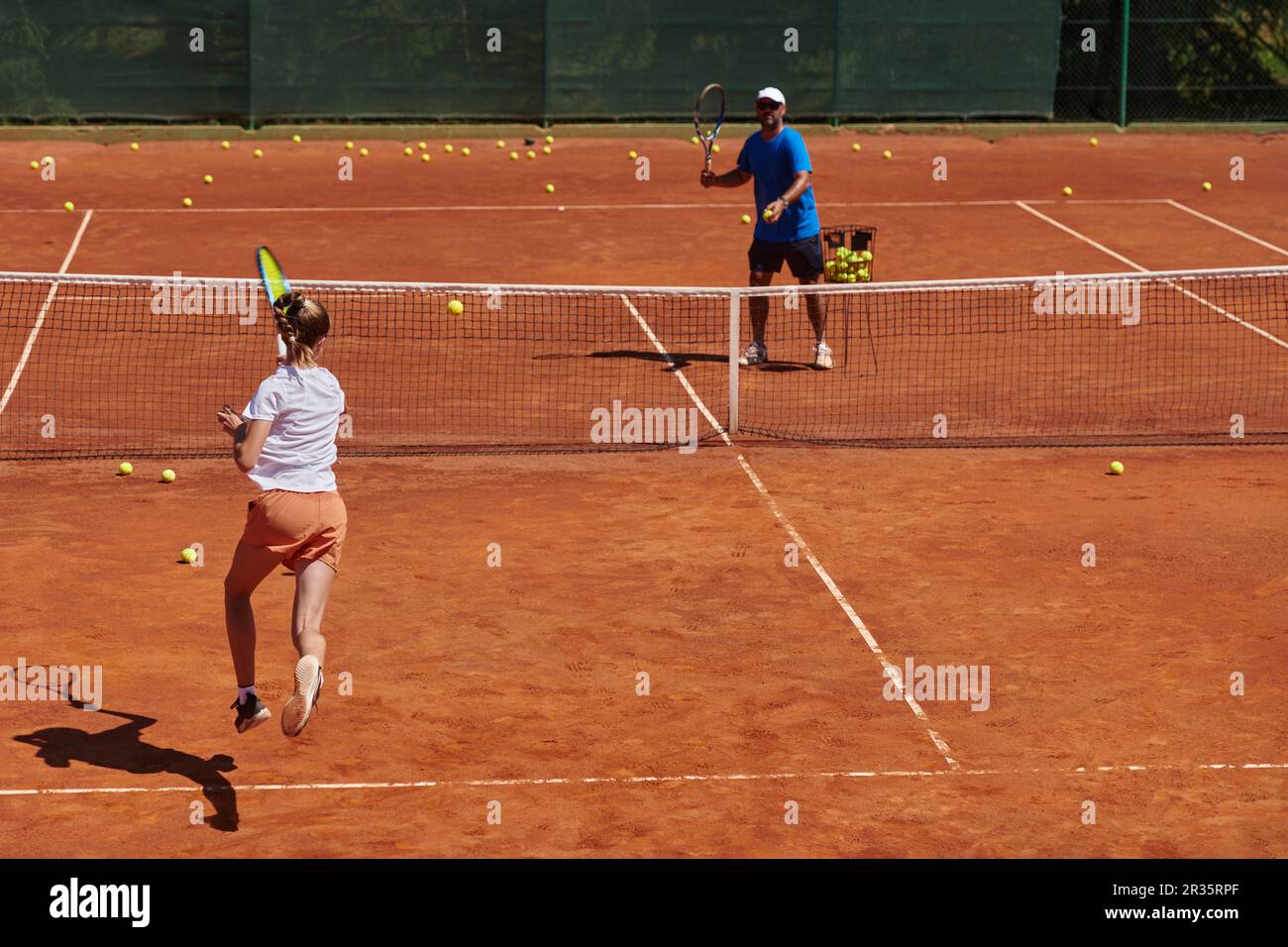 A professional tennis player and her coach training on a sunny day at ...