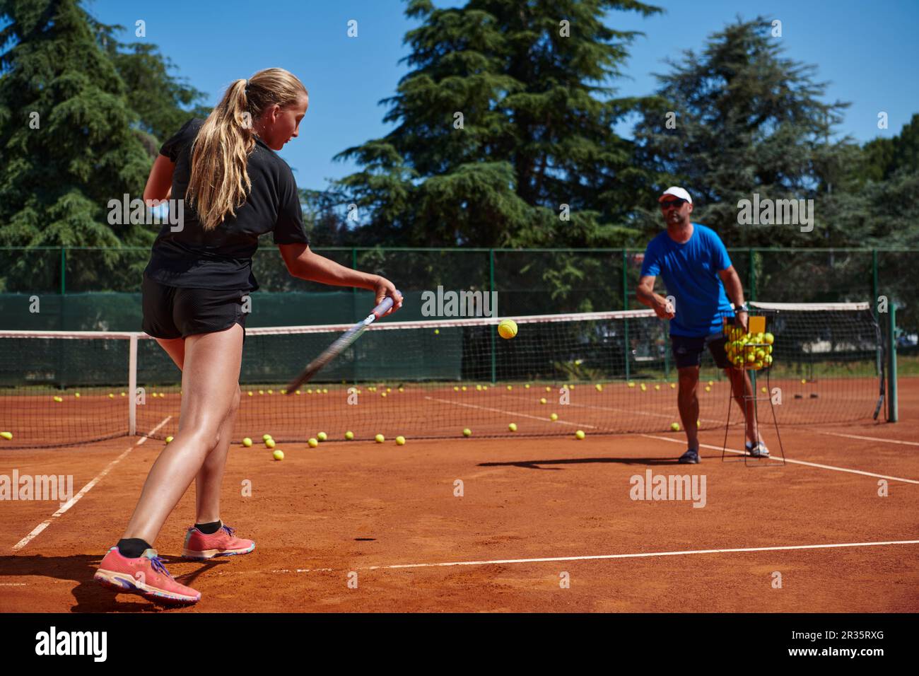 A professional tennis player and her coach training on a sunny day at ...