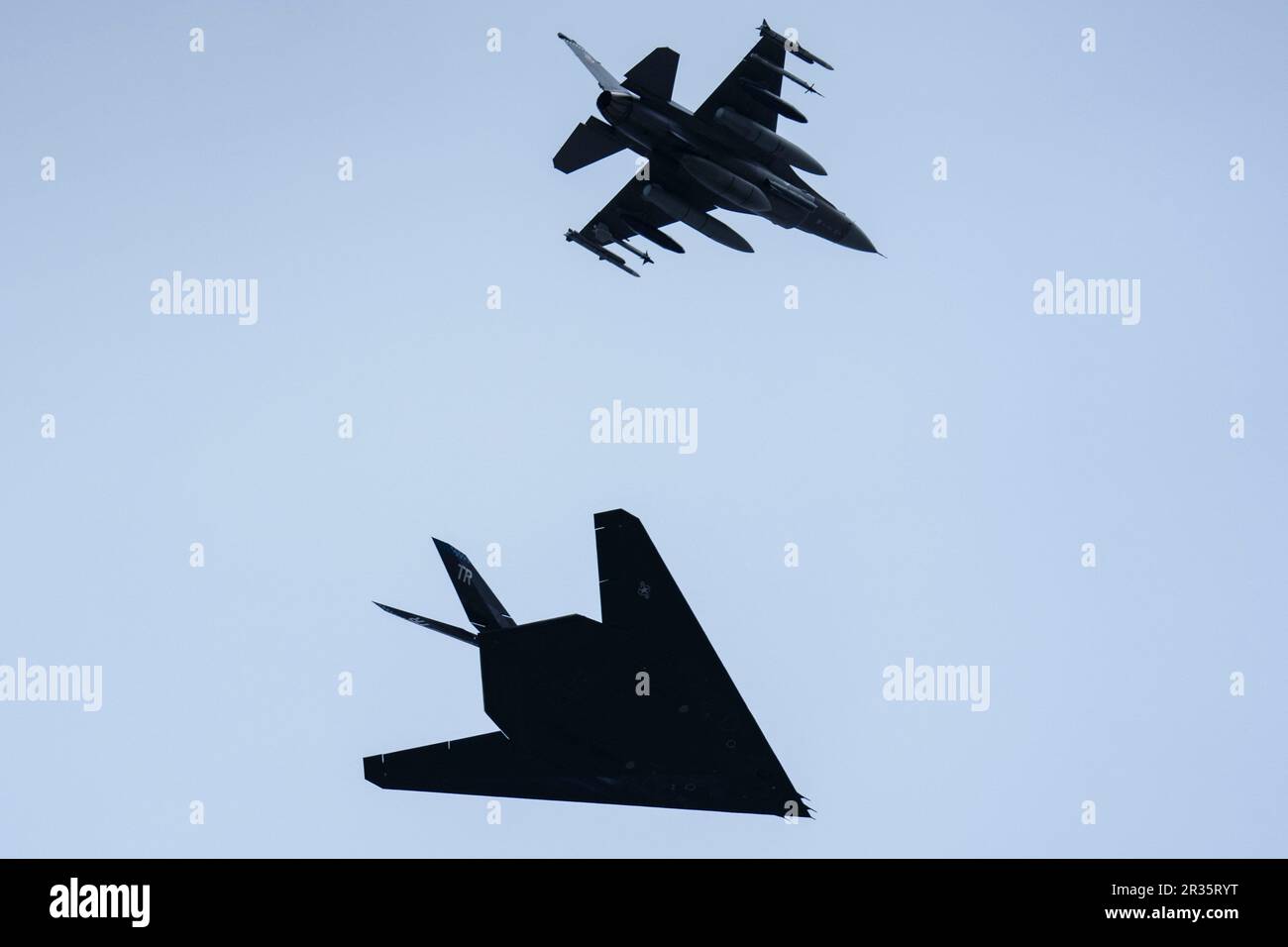 A U.S. Air Force F-117 Nighthawk escorted by a F-16 Fighting Falcon ...