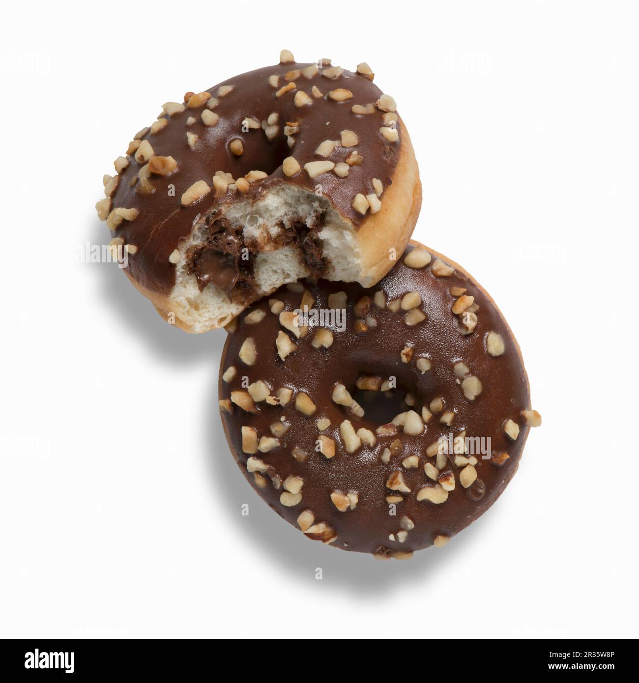 Two nutella doughnuts with chocolate glaze and chopped hazelnuts, one ...