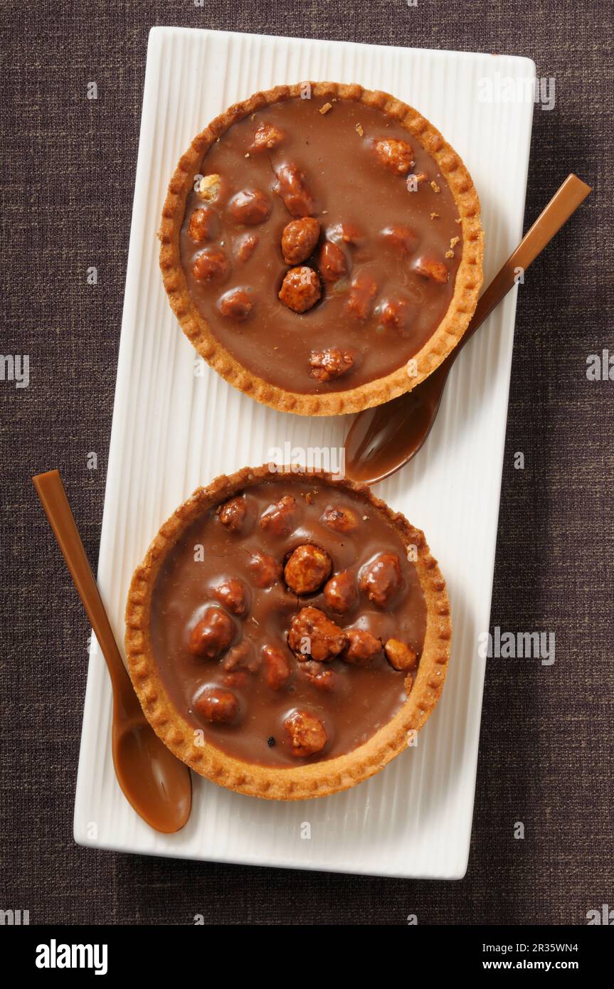 Chocolate tartlets with double-crunch nuts Stock Photo - Alamy