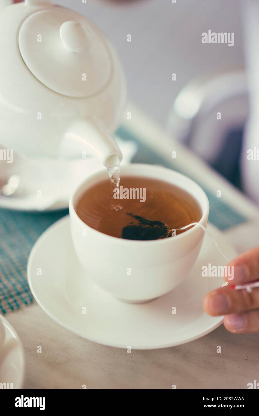 Mans hand pouring tea hi-res stock photography and images - Alamy
