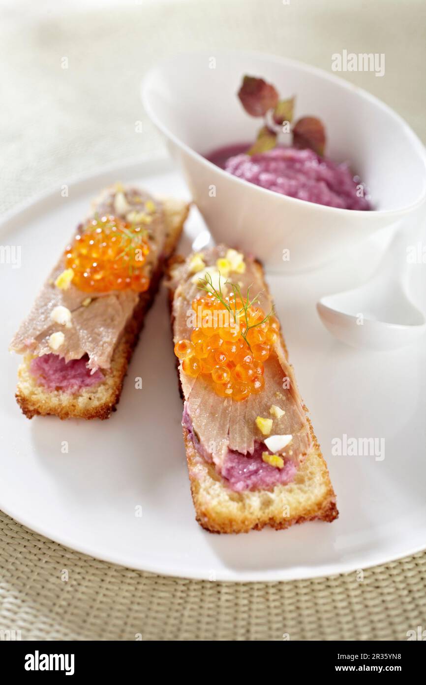Tartine with tuna fish fillets, caviar and mashed purple potatoes Stock ...