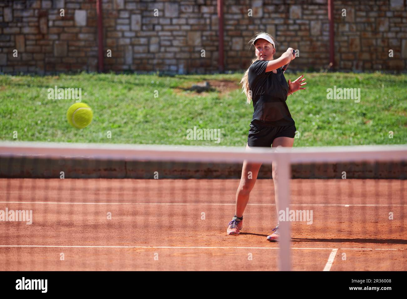 A young girl showing professional tennis skills in a competitive match ...