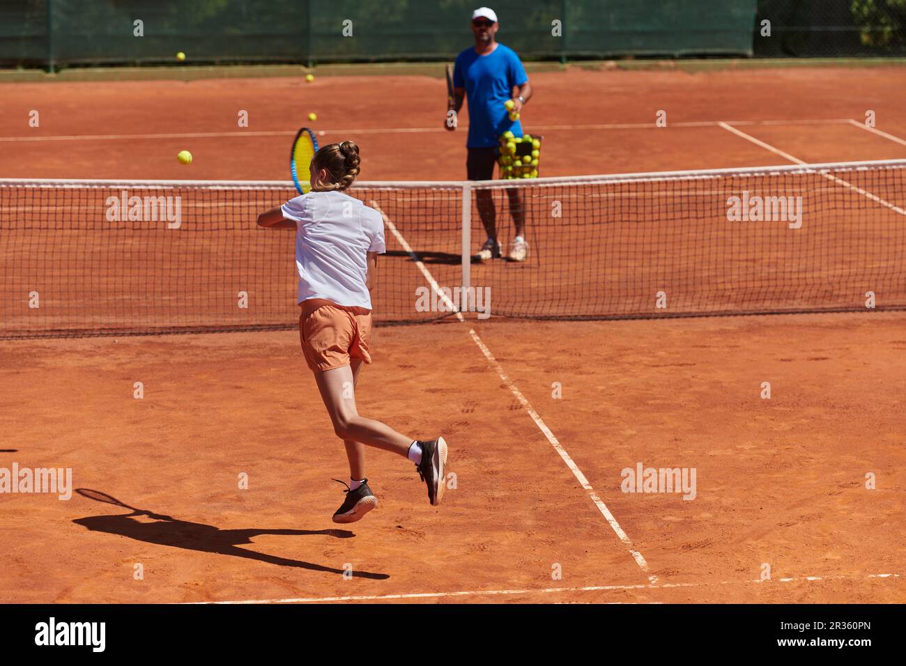 A professional tennis player and her coach training on a sunny day at ...