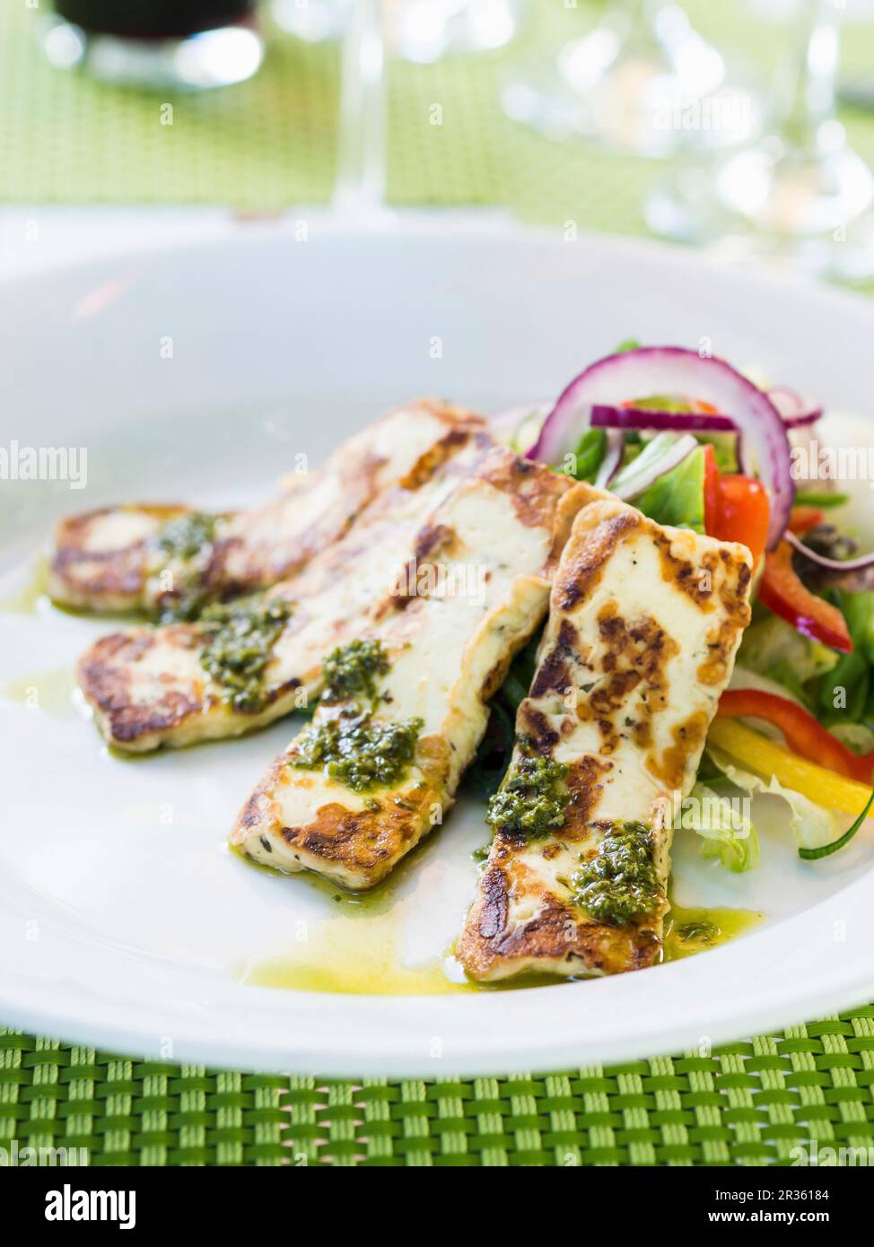 Grilled halloumi cheese served with pesto and salad Stock Photo - Alamy