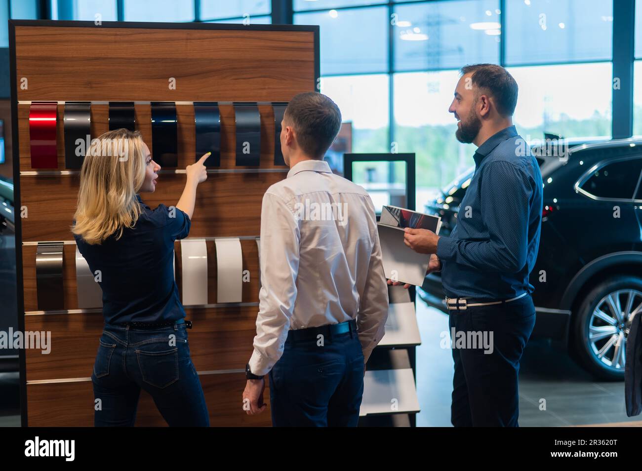 The seller helps a married couple choose the color of a new car Stock ...