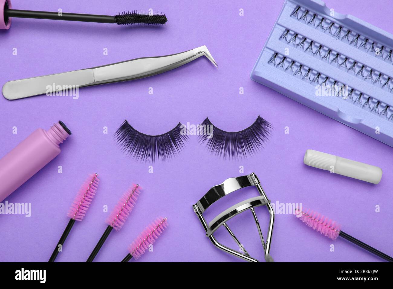 Flat lay composition with fake eyelashes, brushes and tools on lilac ...
