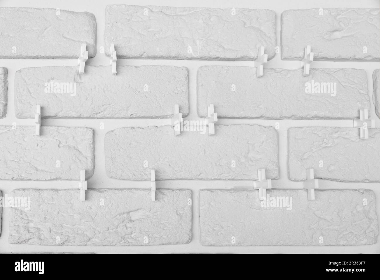 Decorative white bricks with tile leveling system on wall Stock Photo ...