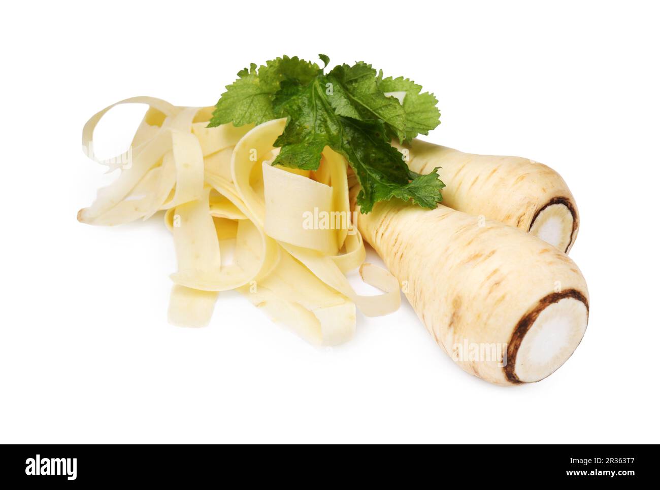 Whole and sliced fresh ripe parsnip with leaves on white background ...