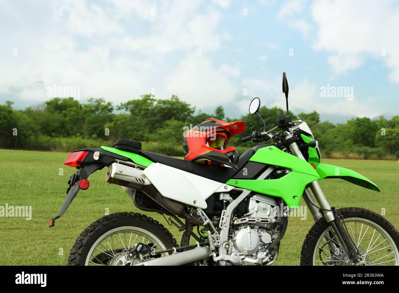 Stylish green cross motorcycle with helmet outdoors Stock Photo - Alamy