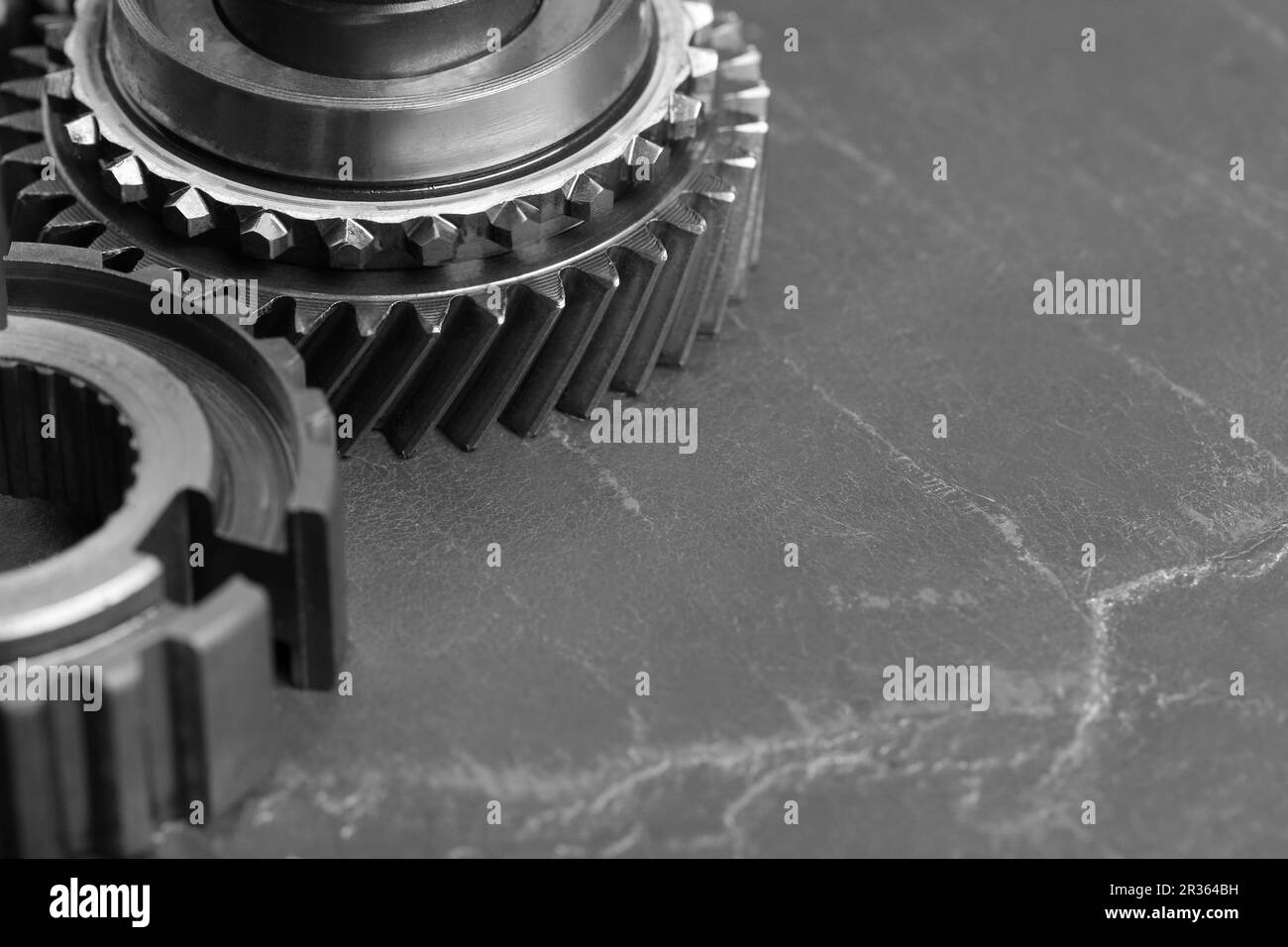 Different stainless steel gears on grey background, closeup. Space for ...