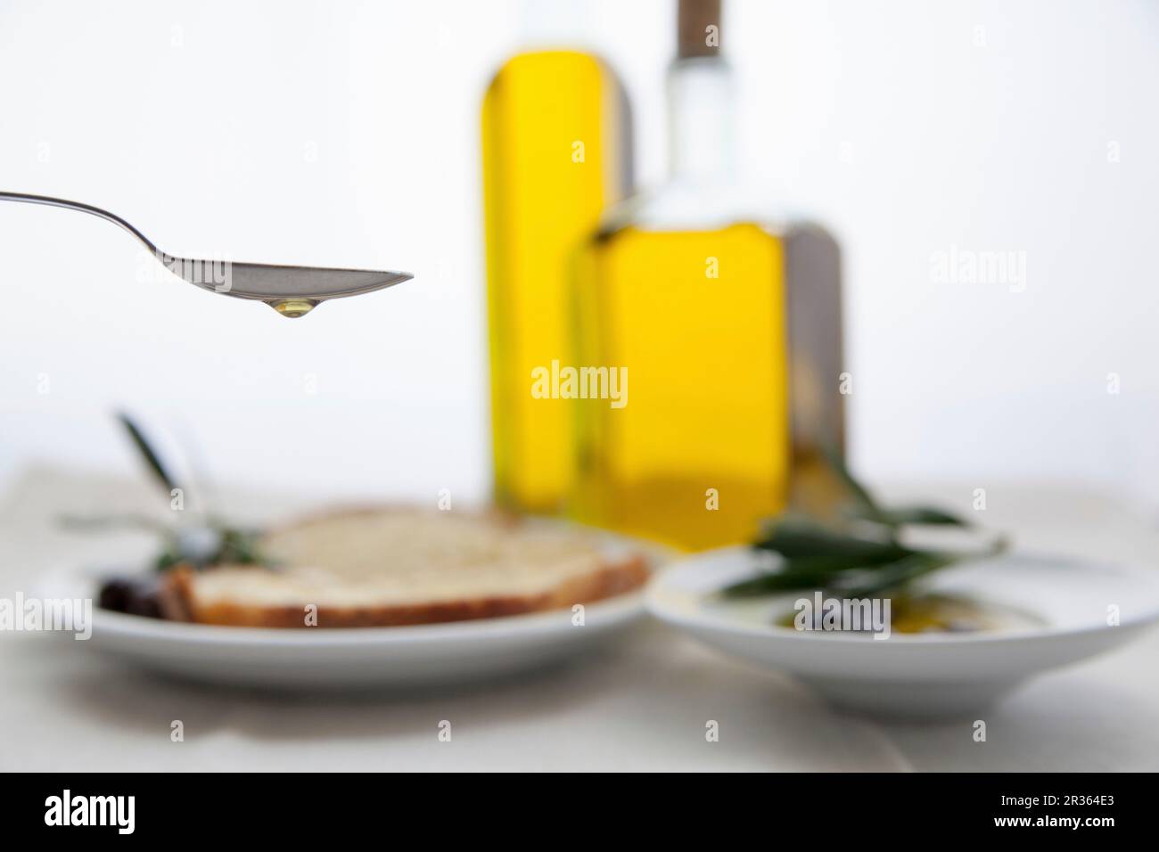 Olive oil dripping from a spoon Stock Photo - Alamy