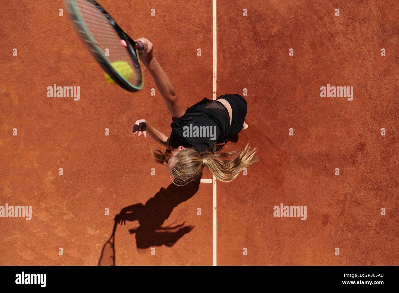 Top view of a professional female tennis player serves the tennis ball ...