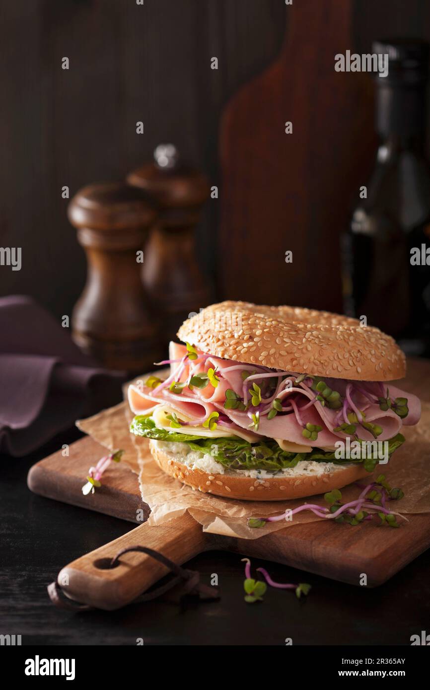 A bagel with ham, cream cheese and radish sprouts Stock Photo - Alamy
