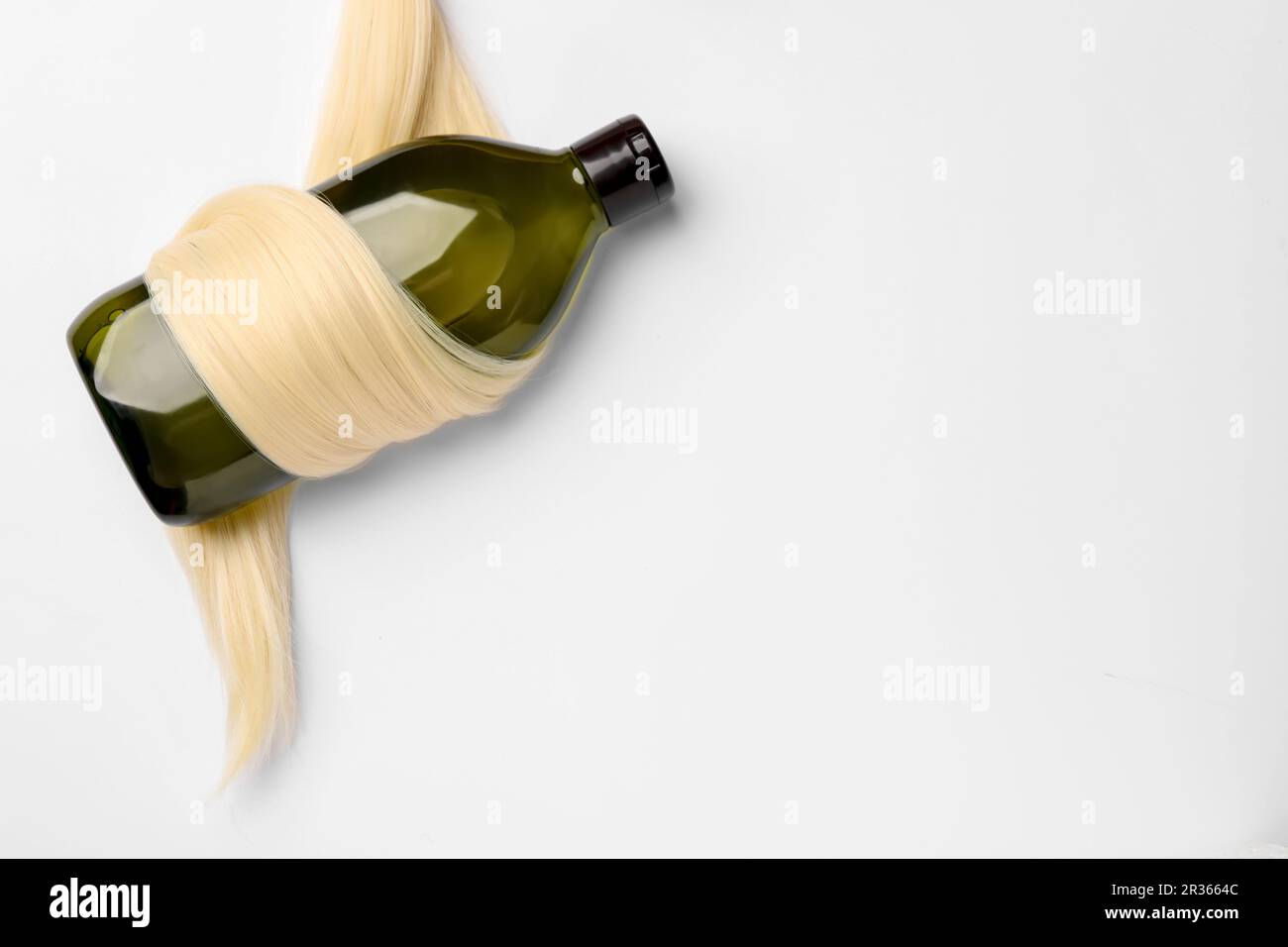Shampoo bottle wrapped in lock of hair on white background, top view ...