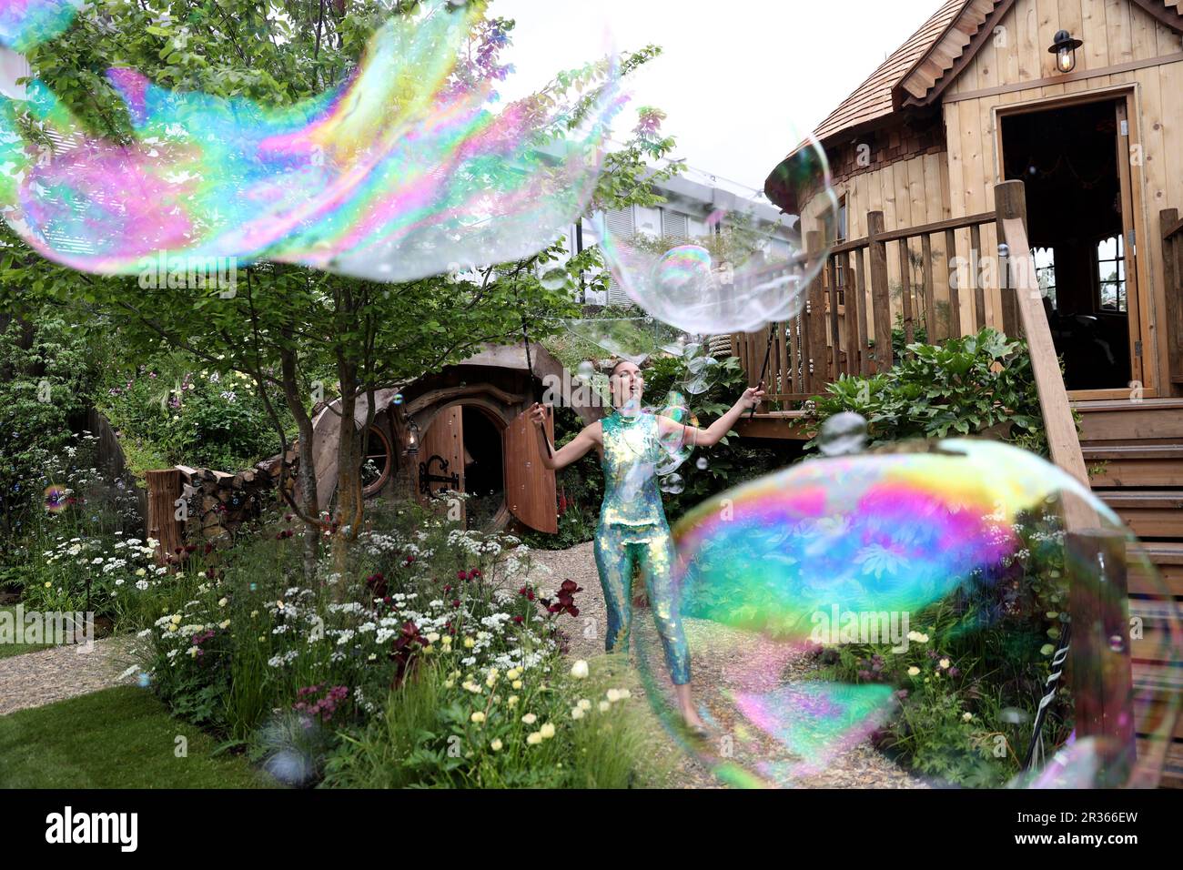 London, Britain. 22nd May, 2023. A woman makes giant soap bubbles at ...