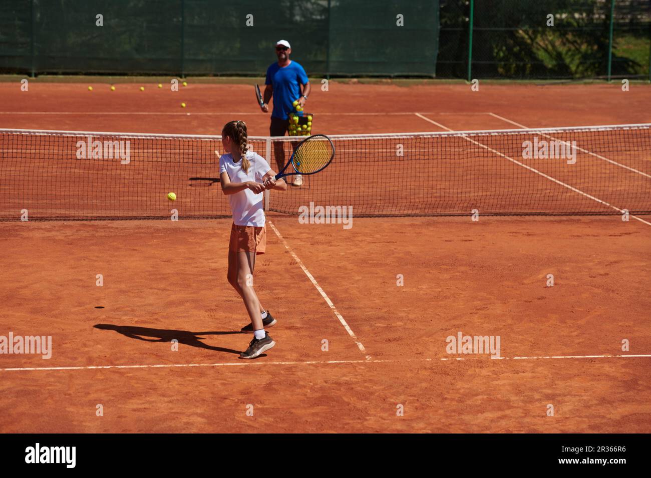 A professional tennis player and her coach training on a sunny day at ...