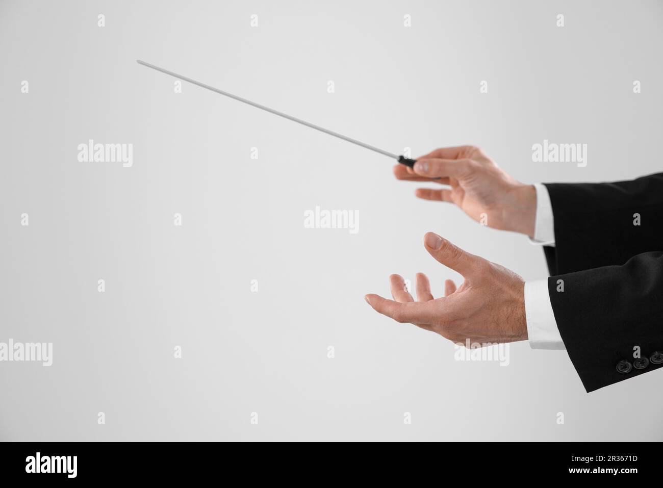 Professional conductor with baton on light grey background, closeup ...