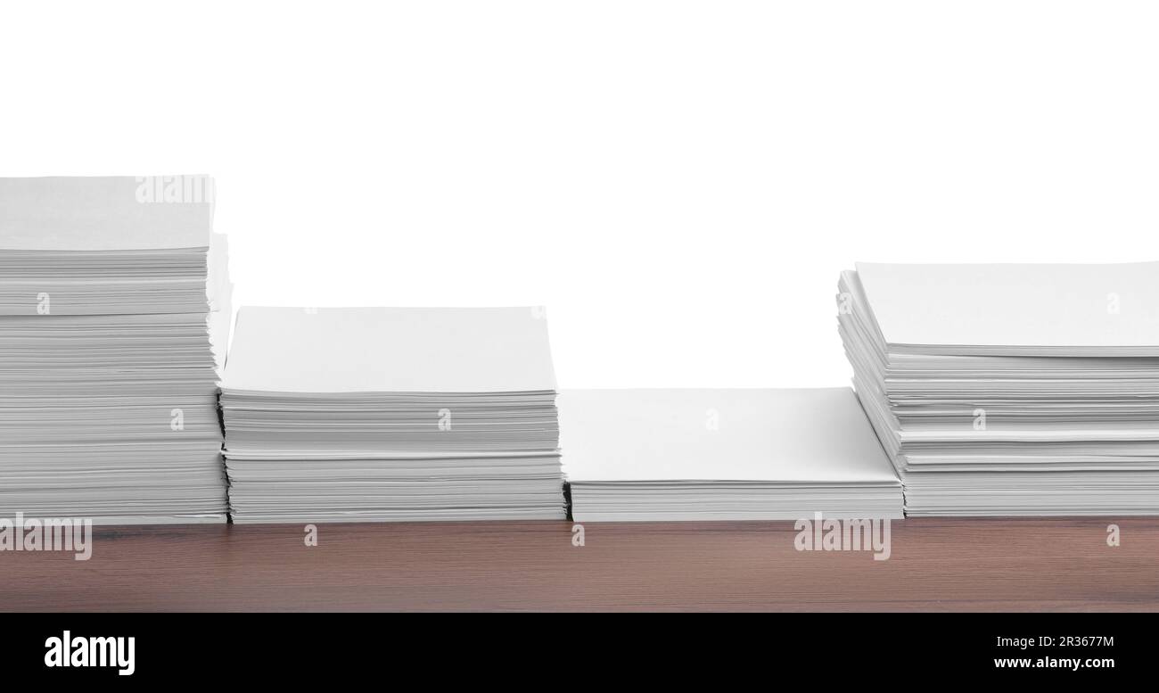 Stacks of paper sheets on wooden table against white background Stock ...