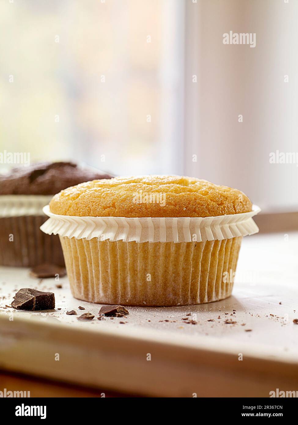 Two different muffins in front of a window Stock Photo - Alamy