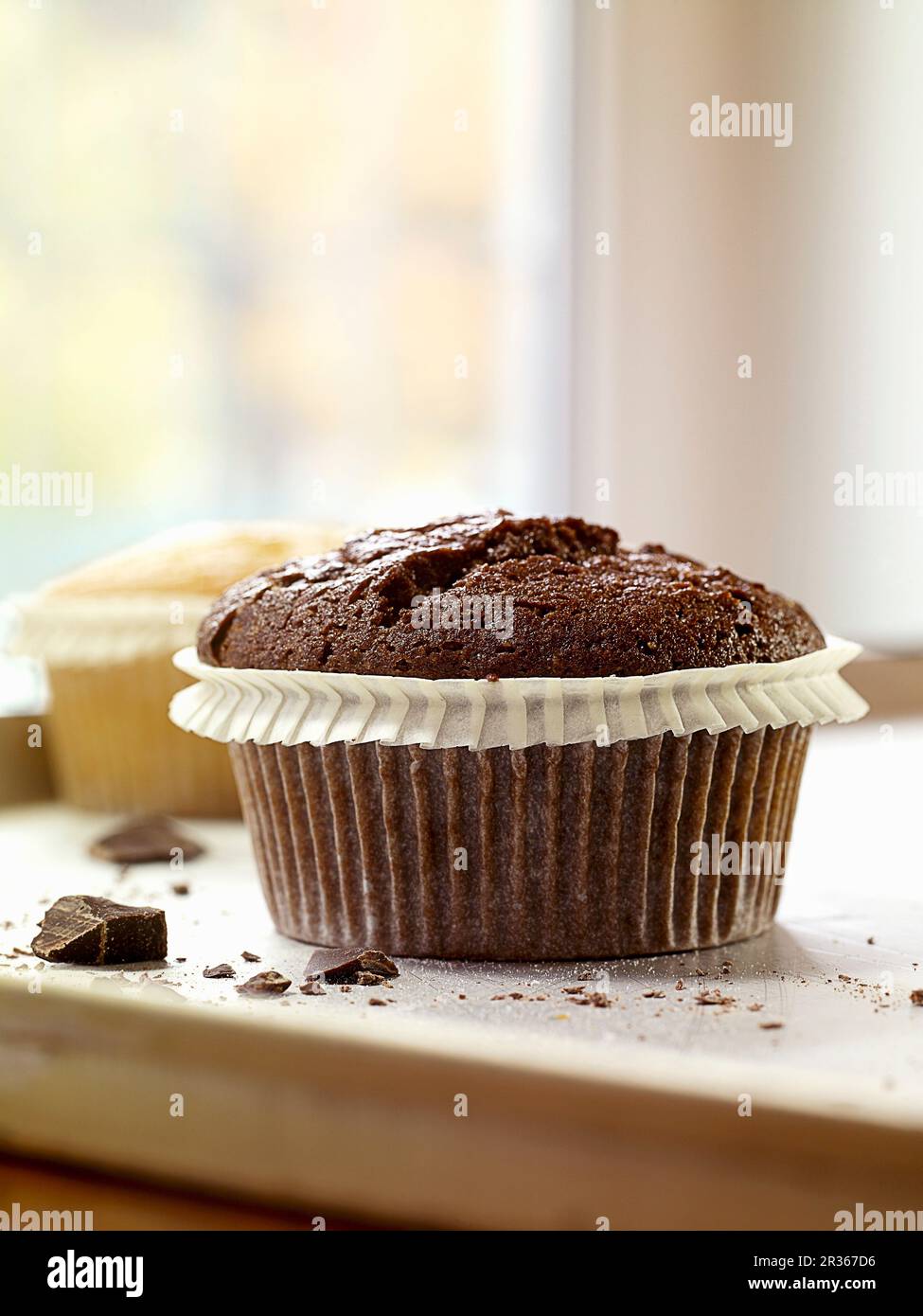 Two different muffins in front of a window Stock Photo - Alamy