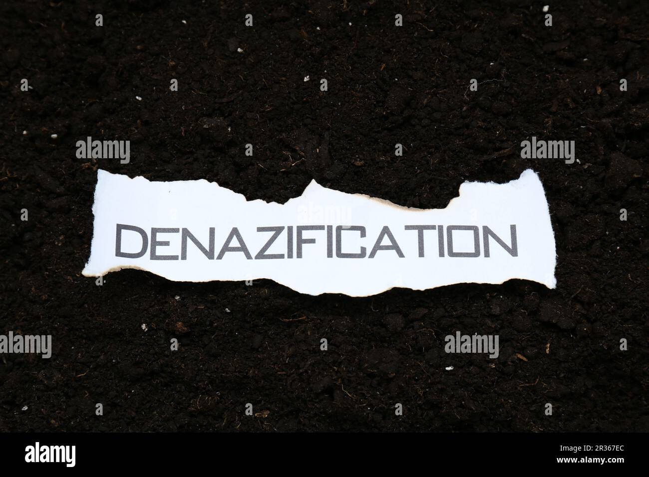 Piece of torn paper with word Denazification on soil, top view Stock ...