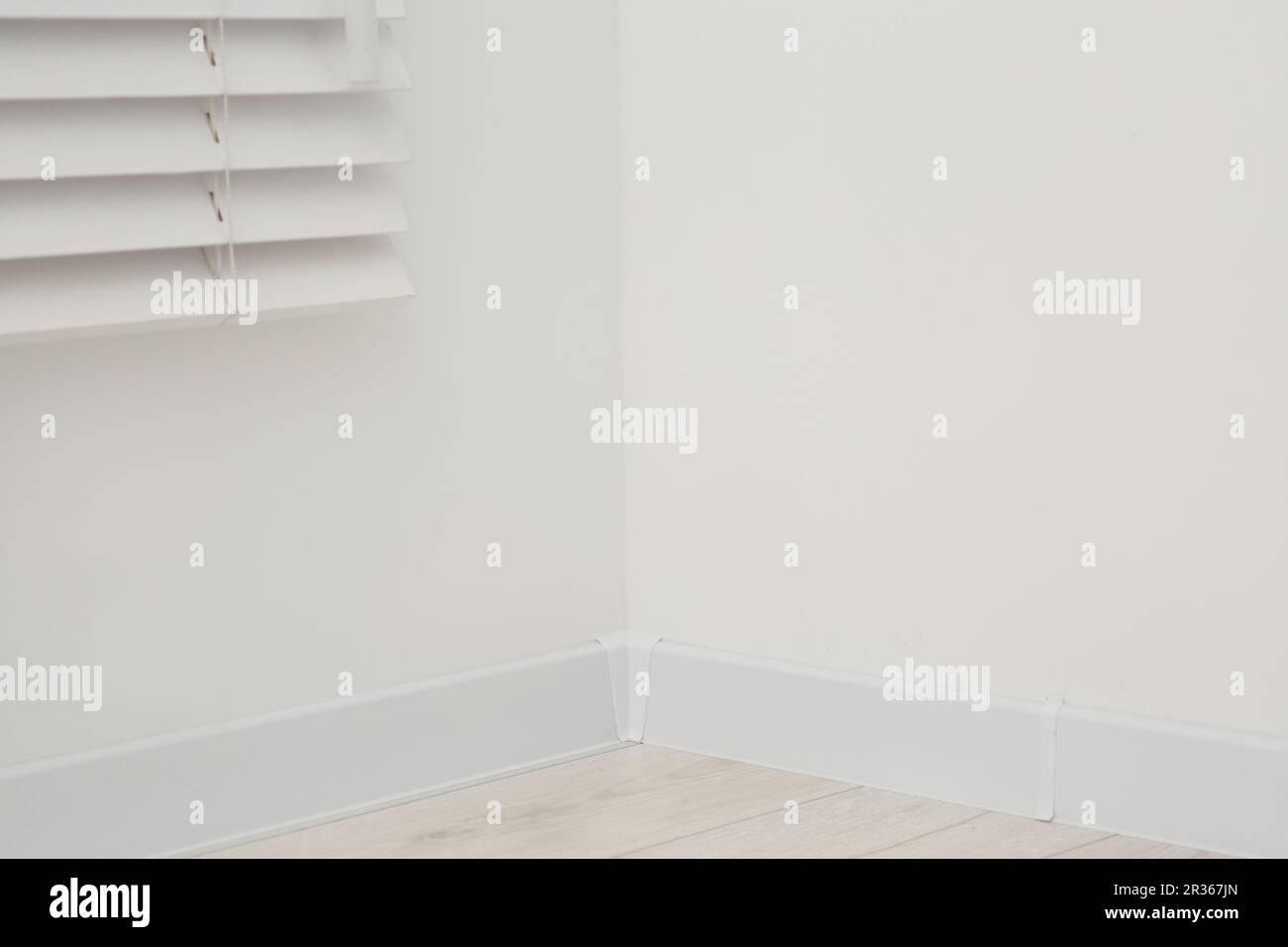 Corner of white wall with baseboard indoors Stock Photo - Alamy