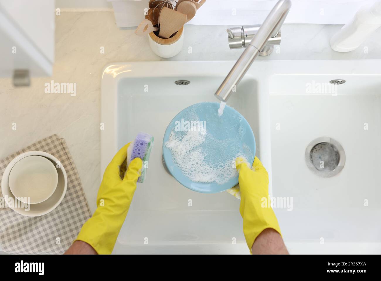 Man washing plate in kitchen sink, top view Stock Photo - Alamy
