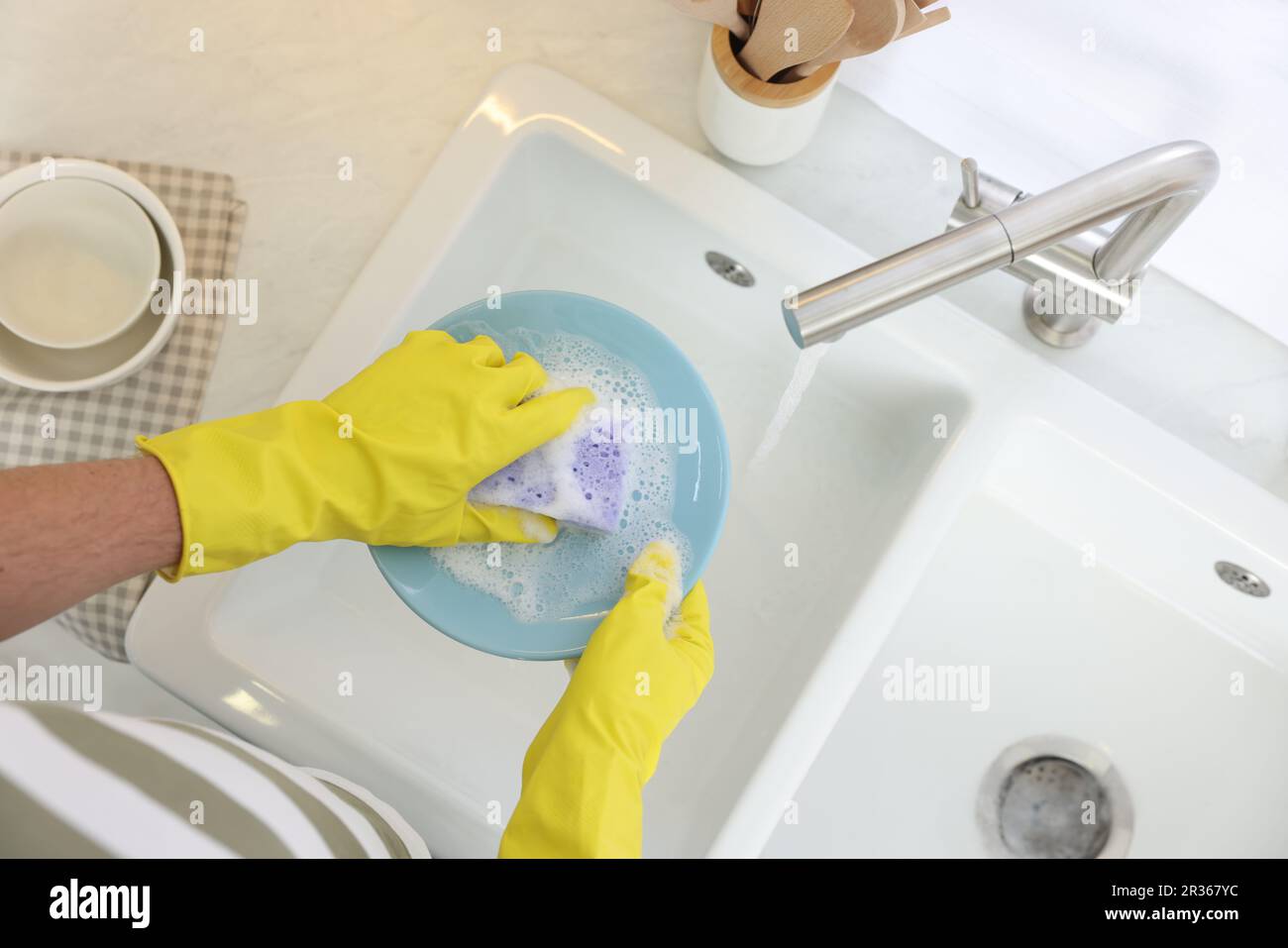 Man washing plate in kitchen sink, top view Stock Photo - Alamy