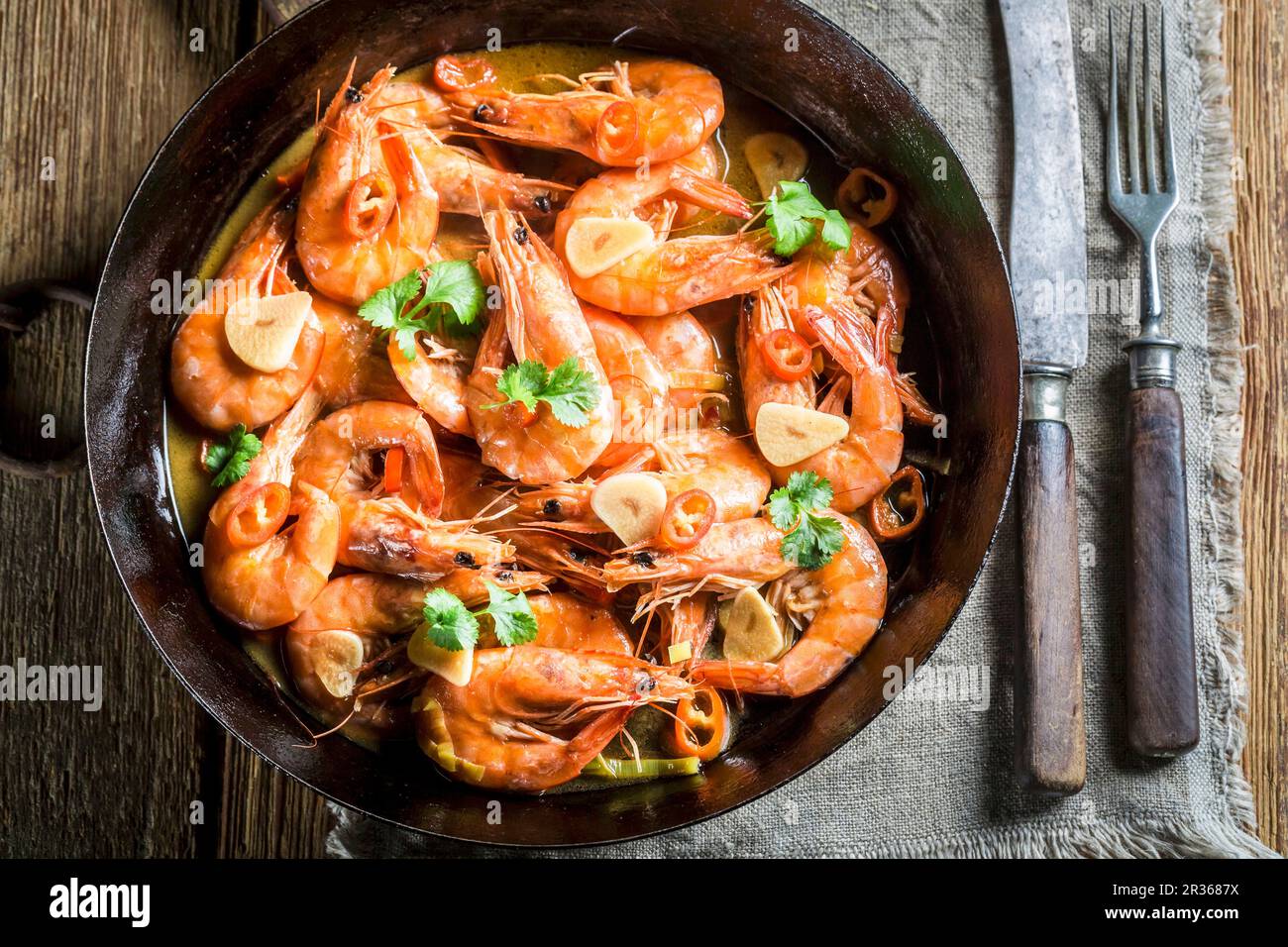 Prawns with garlic, parsley and chilli peppers Stock Photo - Alamy