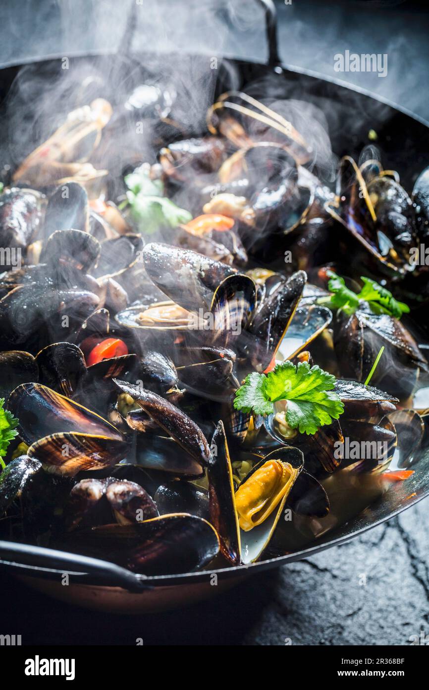 Steaming mussels with garlic and parsley Stock Photo - Alamy