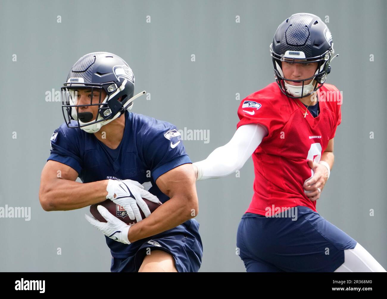 Seattle Seahawks quarterback Drew Lock, right, hands off the ball to ...
