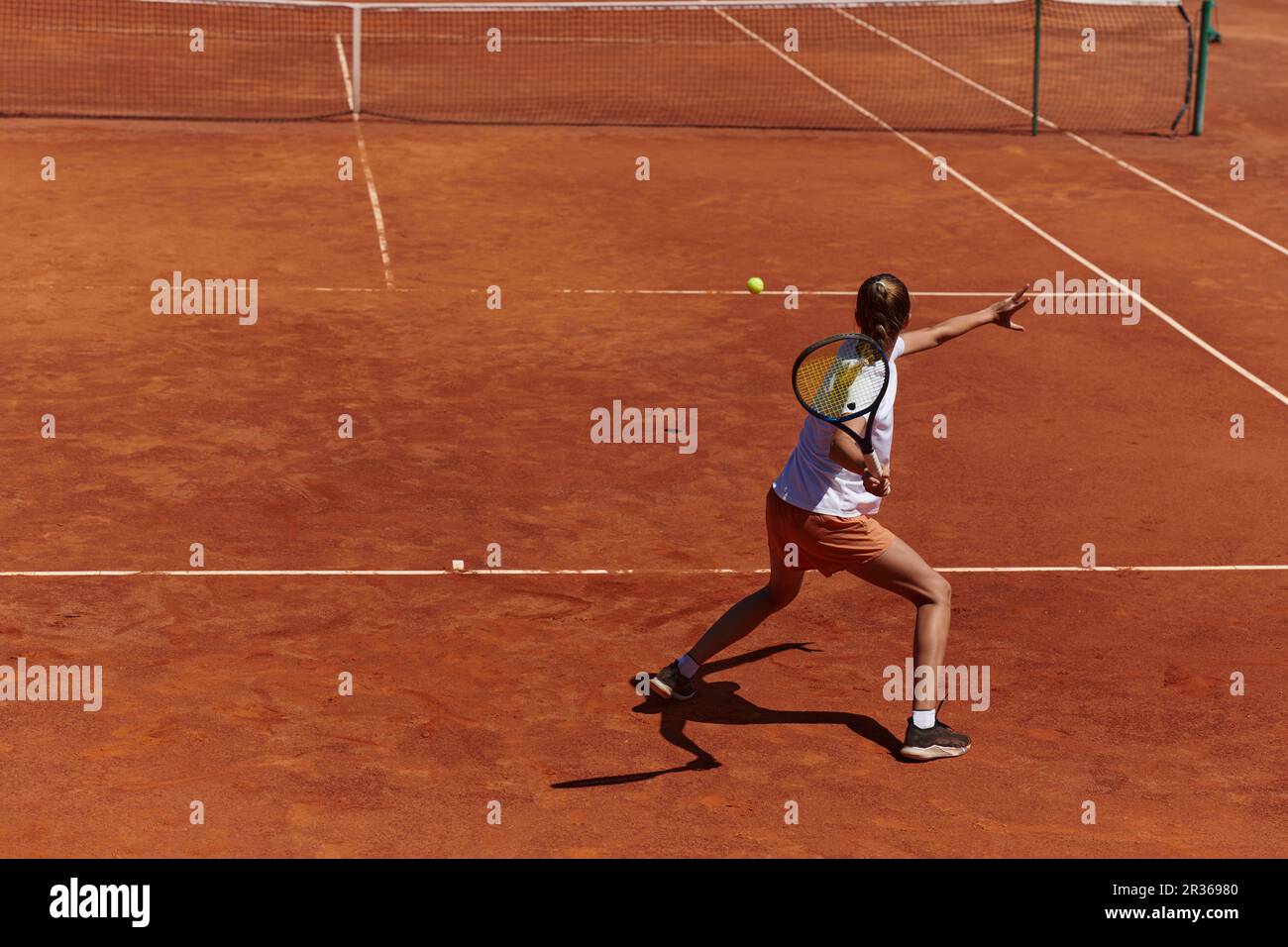 A young girl showing professional tennis skills in a competitive match ...